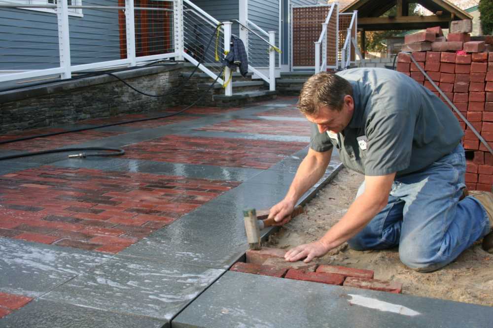 Slawomir sets brick into a compacted bed of sand.